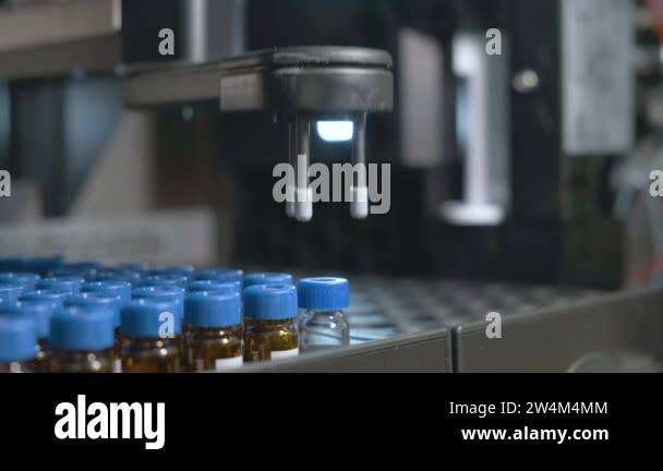 Auto sampler takes a vial and injects a sample into high performance liquid chromatography Stock ...