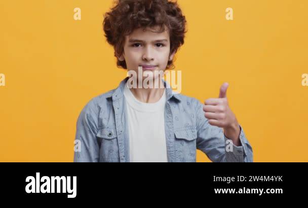 Children approval. Adorable curly little boy nodding head and showing ...