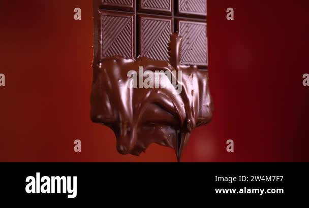Chocolate bar with melted chocolate flowing in slow motion. Close up ...