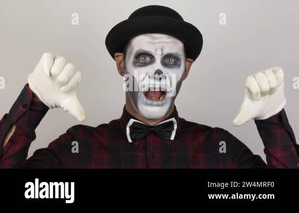 Terrible man in clown makeup, showing a thumb down. The scary clown ...