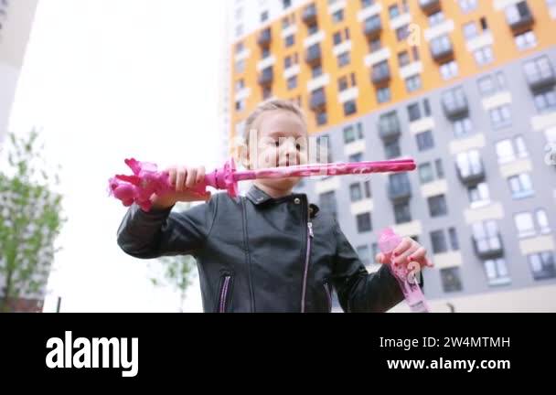 Bottom view of a female child blowing bubbles and laughing. Action ...