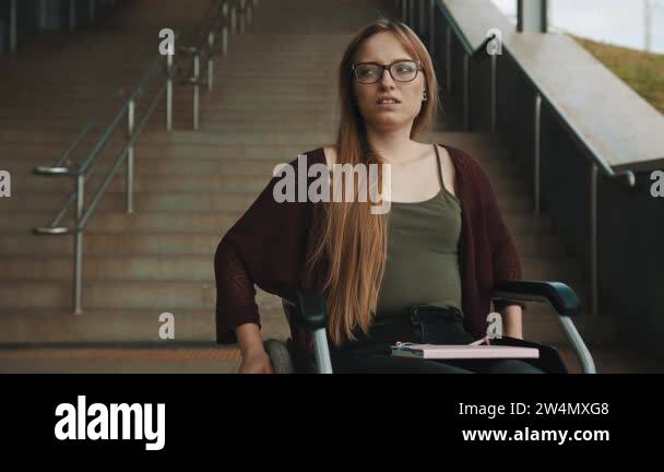 Sad helpless disabled young woman in front of the stairways in the ...