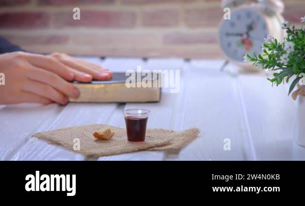Young woman reading the Bible and taking communion - the wine and the ...