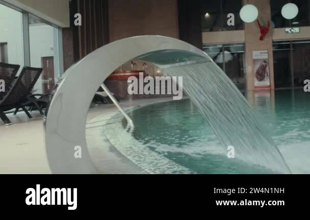 Waterfall jet in swimming pool. Fountain for hydromassage in luxury ...