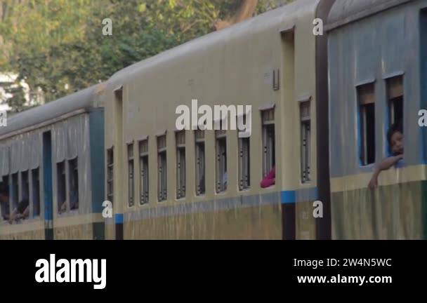 TRAIN LOCOMOTIVE: Side view train slowly moves past with passenger ...