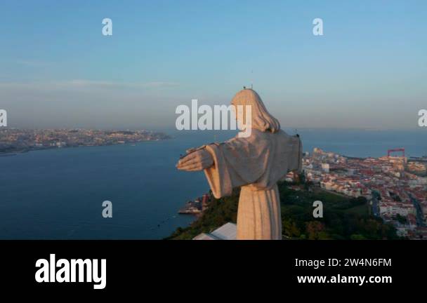 Big stone statue of Jesus illuminated by last sun rays of day. Drone ...