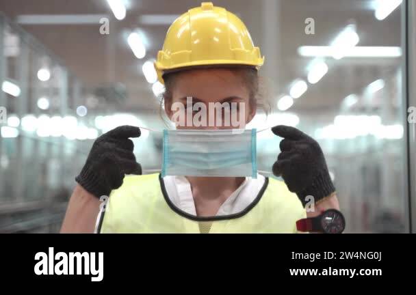 Labor woman worker is wearing protection mask face and safety helmet ...