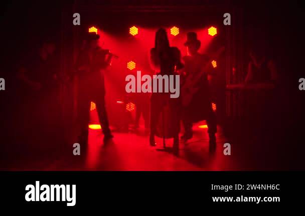 Rock band musicians in the studio play songs with red lights on the ...