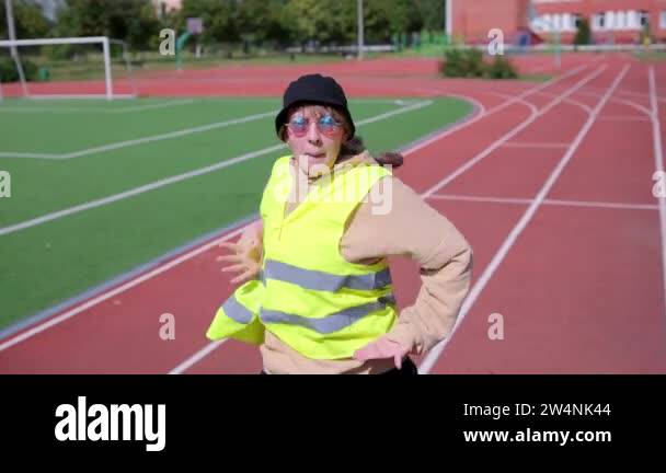 young girl performs complex acrobatic figures outdoors in a stadium ...