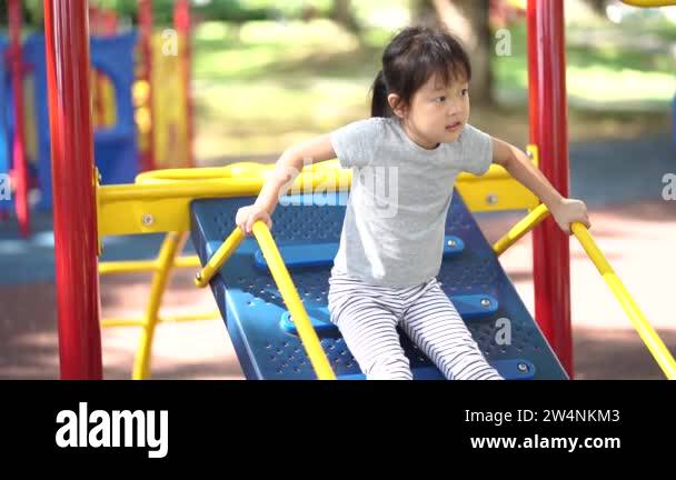Asian chinese girl navigating difficult outdoor obstacles with smiles ...