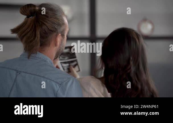 couple family looking at x-ray film baby. Maternity prenatal care and ...