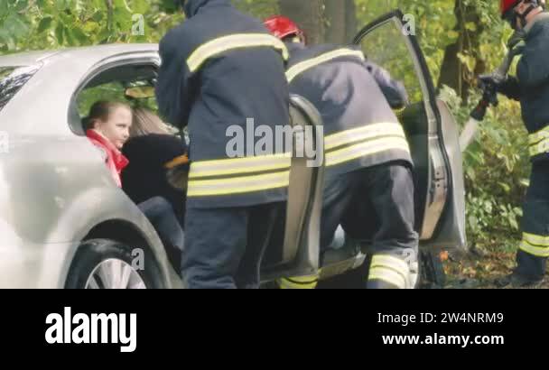 Firefighters saving people and extinguishing fire after car crash Stock ...