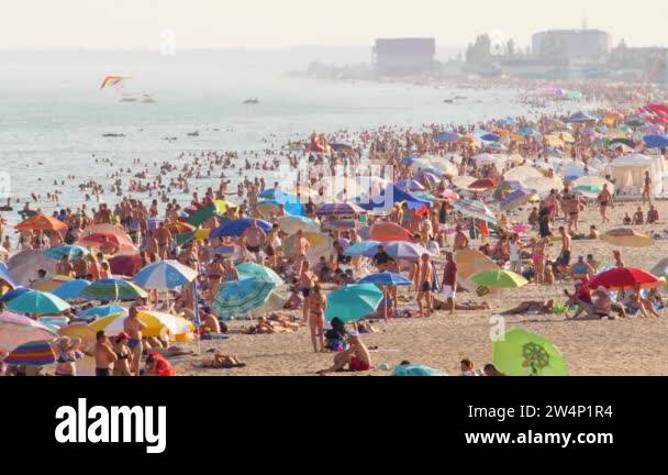 Beach full of people and sun umbrellas. Busy day on the beach. Crowd on ...