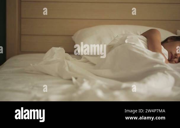 Adorable little girl sleeping in a bed. Dolly shot left to right Stock ...