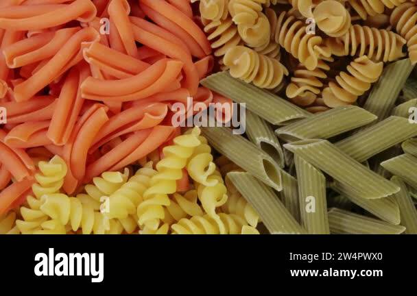 Multicolored Pasta rotating in slow motion top view. Rotation of ...