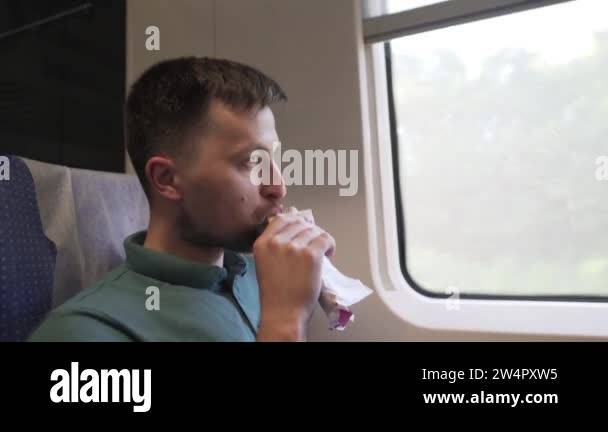 Caucasian male traveler travels in a passenger high-speed train at the ...