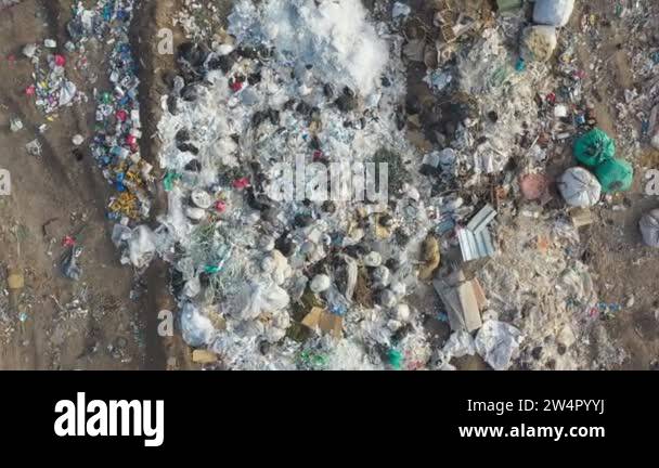 Aerial shot of rubbish pile lying among countryside. Flying over huge ...