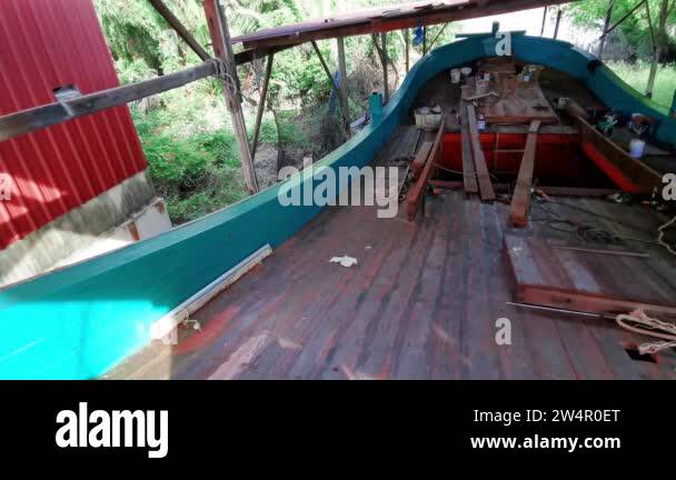 Pan down low light onboard view of a traditional wooden boat under ...