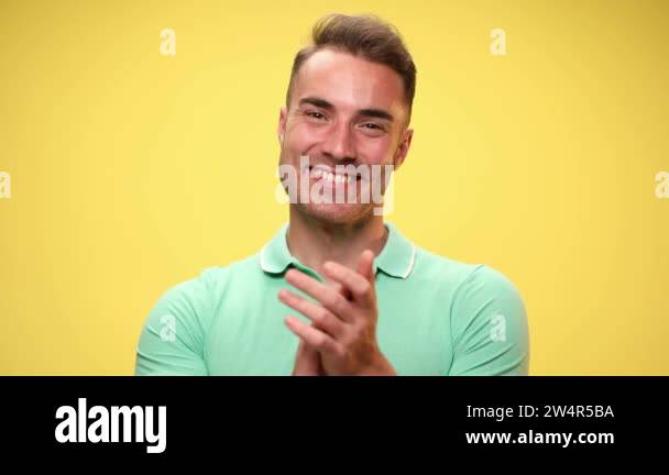 handsome young casual man clapping hands, giving a thumbs up, pointing ...