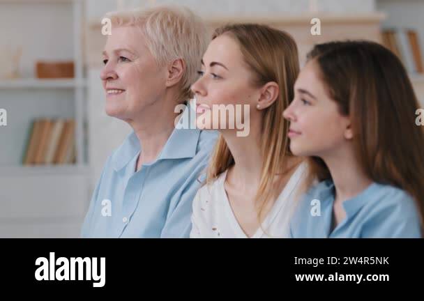 Three generation of women in living room. Elderly gray-haired female ...