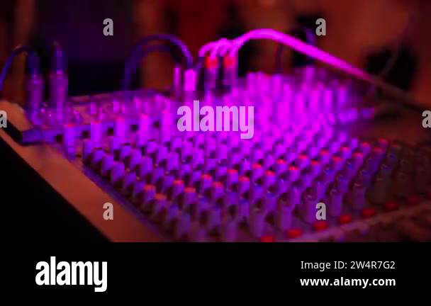 Close-up of DJ music console illuminated with led flashing lights at ...