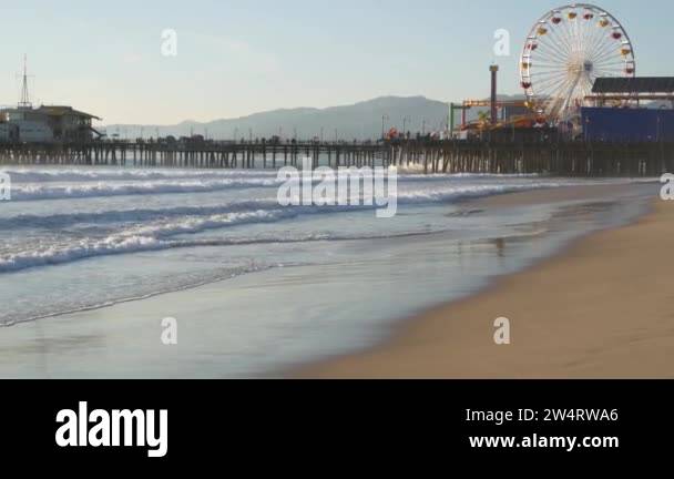 Ocean waves and sandy california beach, classic ferris wheel in ...
