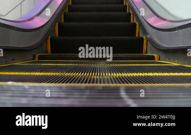 Low angle looped perspective view of modern escalator stairs. Automated ...
