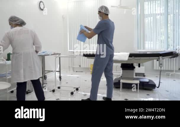 Male and female nurses preparing a sterile room for the surgical ...