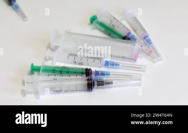 Many different sized injection syringes lie on a white tabletop Stock ...