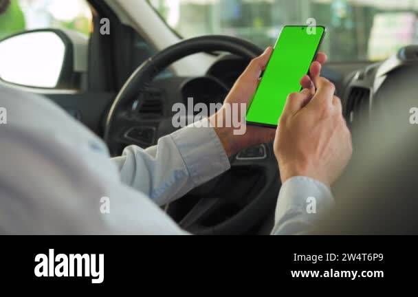 Driver using a smartphone inside the car. Chromakey smartphone with ...