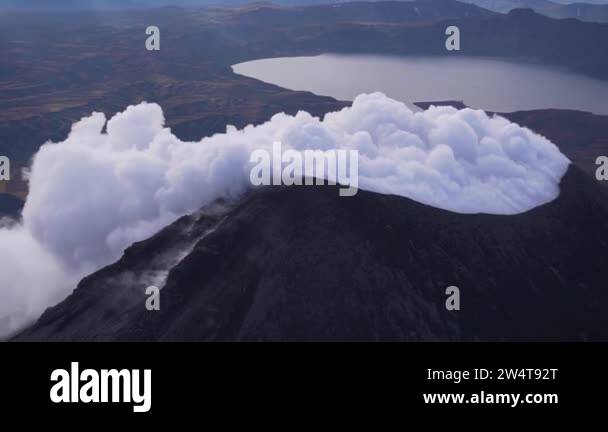 The crater of Karymsky volcano on the Kamchatka Peninsula thick white ...