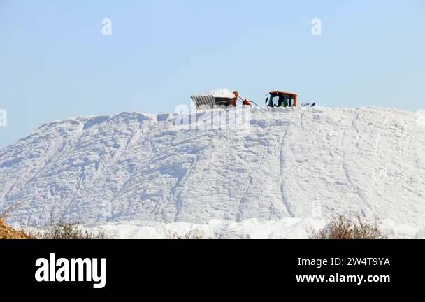Huelva, Spain - October 1, 2020: Excavator working in a huge pile salt ...