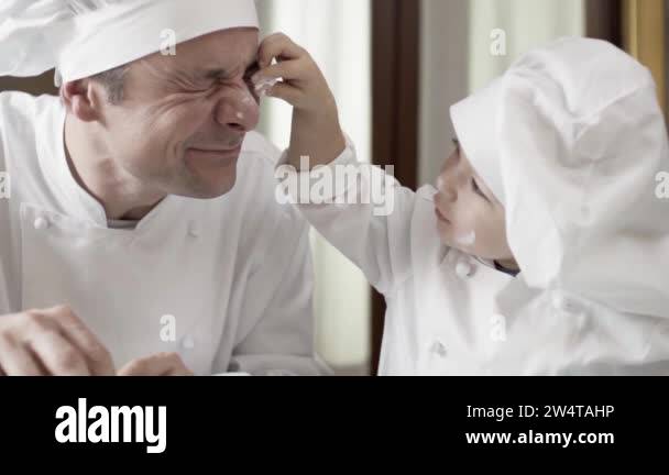 Dad and son playing with flour while cooking cake. Family activities ...