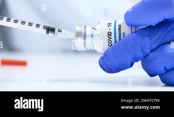 Female doctor hands with transparent liquid coronavirus vaccine bottle ...