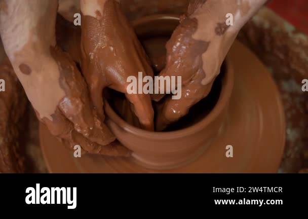Teaching pottery A craftsman hands guiding a woman hand, showing how to ...