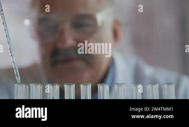 Scientist drop liquid in a test tube and shaking in laboratory. Pipette ...