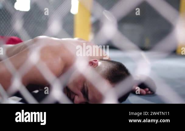 MMA fighter is falling on the floor after being hit and gets up quickly ...