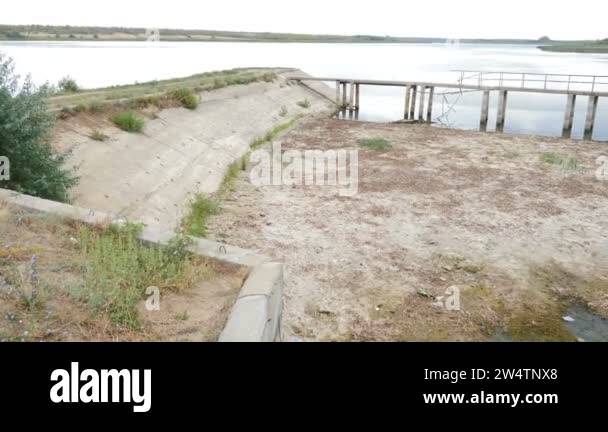 Ecological disaster. cracked soil ground and broken bridge over dried ...
