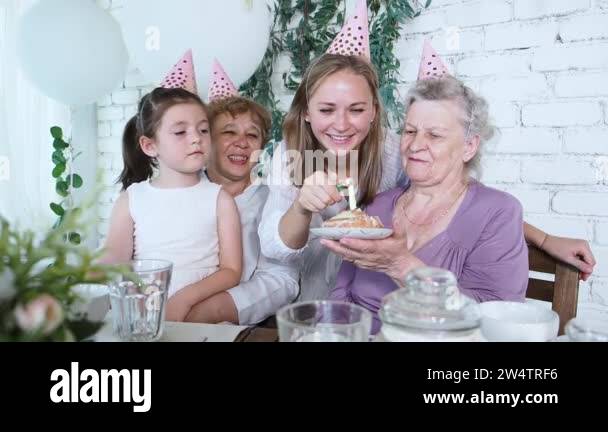 Celebration and family concept. Young girl lights a candle on birthday ...