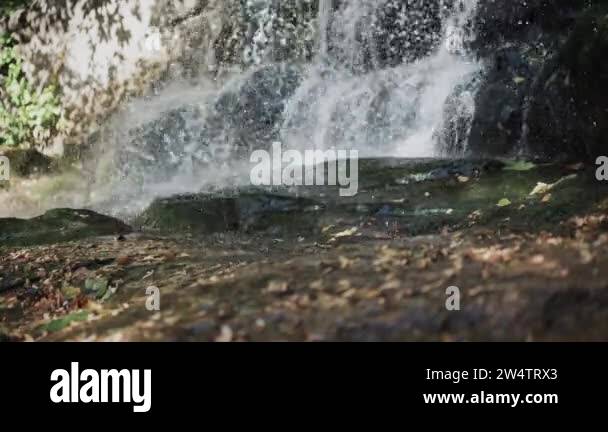 A waterfall in the mountains in nature, splashes falling on the ground ...
