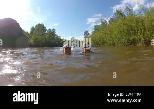 Young boys swimming in river in countryside. Happy kids playing in ...