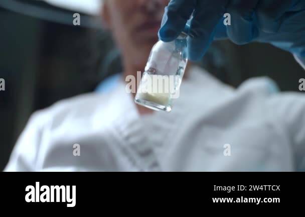 Low angle view of potential vaccine vial in laboratory researchers ...