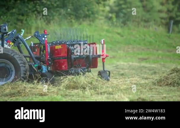 Rotary rakes are moving very fast when the tractor is driving. A young ...