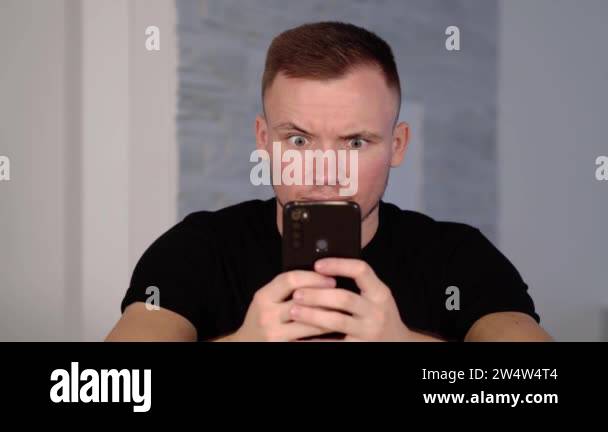 Muscular buggy-eyed man types on phone and becomes crazy Stock Video ...