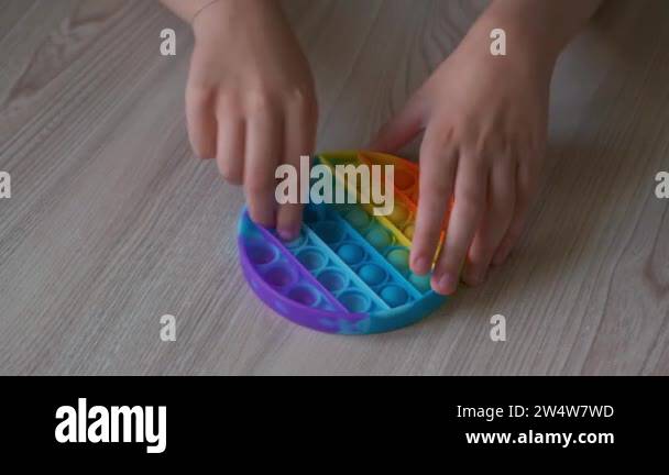 Close up shot of kids fingers on pop it fidget toy. Instrument for ...