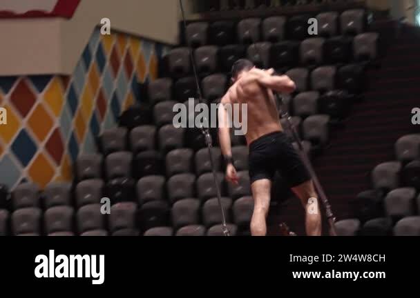 Acrobatic shirtless man jumping on the flying construction for ...