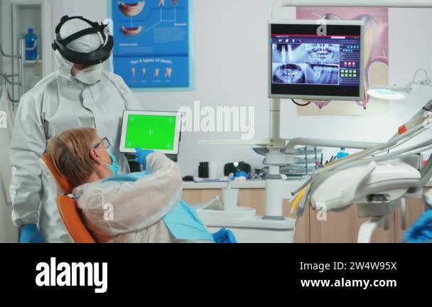 Dentist with face shield pointing at green screen display Stock Video ...