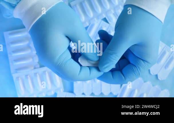 A professional proctologist wearing blue medical gloves opens ...