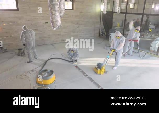 Builders are polishing the floor with special equipment. Concrete ...