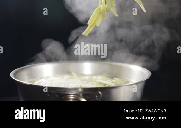 Boiled Italian pasta putting on hot pan for roasting at restaurant ...